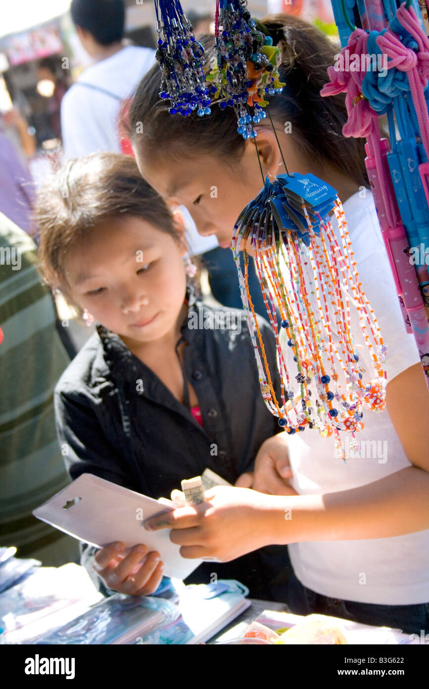 Hmong Children hold money deciding on purchase at concession stand ...