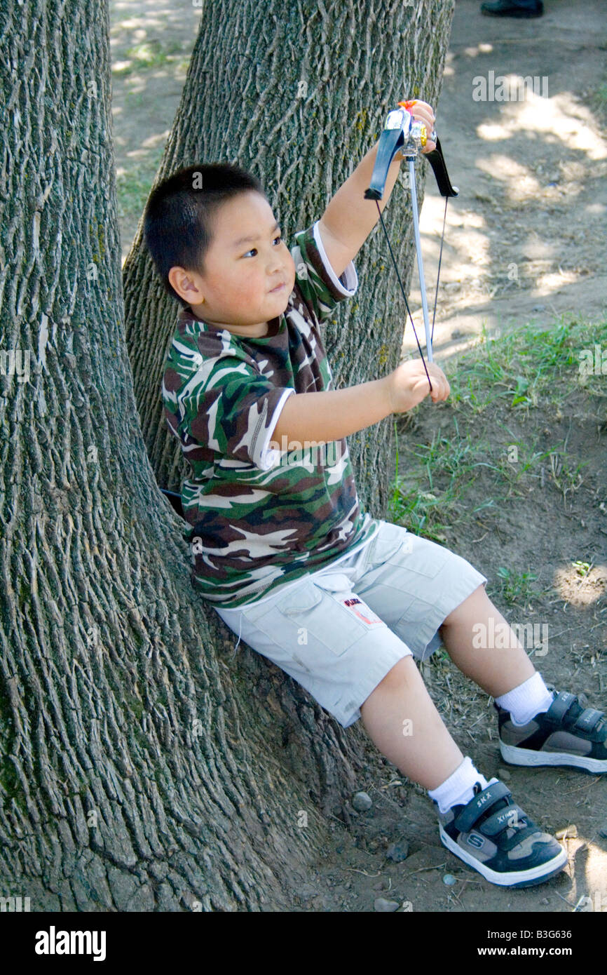 Hmong boy age 8 with camo shirt plays with bow and arrow. Hmong Sports ...