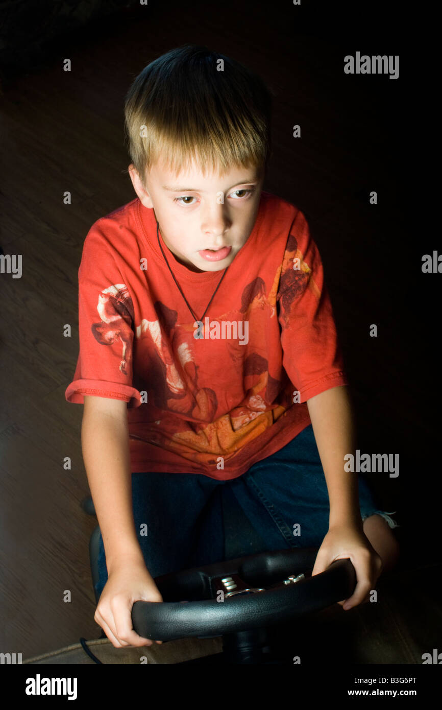 Boy playing with playstation wheel Stock Photo - Alamy