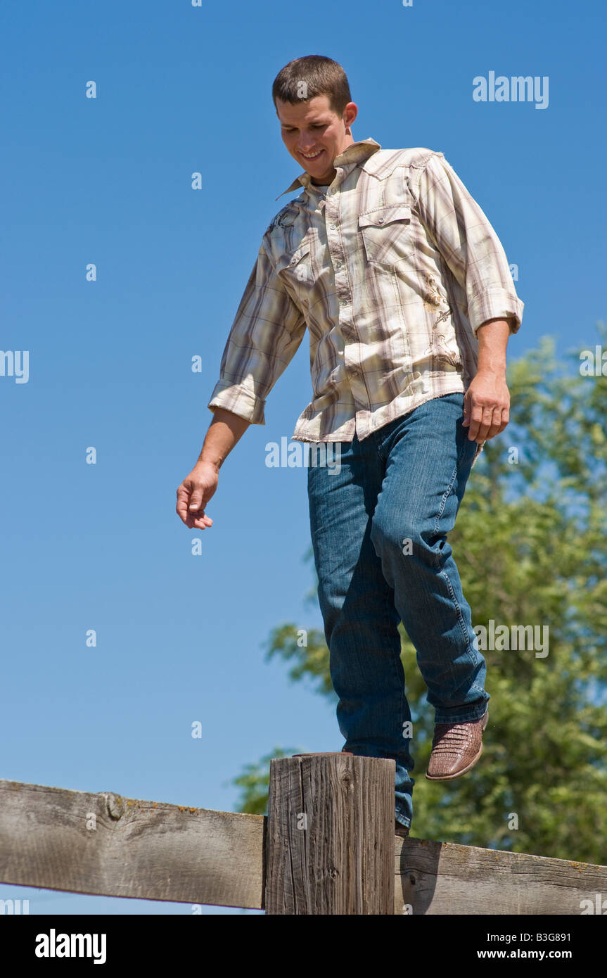 A man walks on a fence on a farm Stock Photo - Alamy