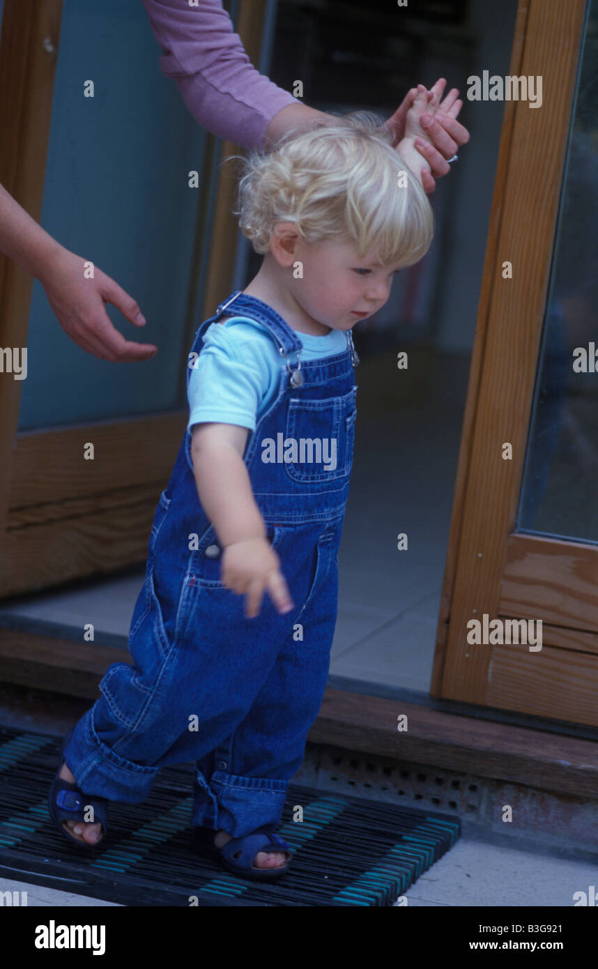 toddler walking with help from his mother Stock Photo - Alamy