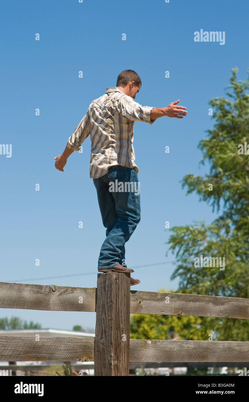 A man walks on a fence on a farm Stock Photo - Alamy