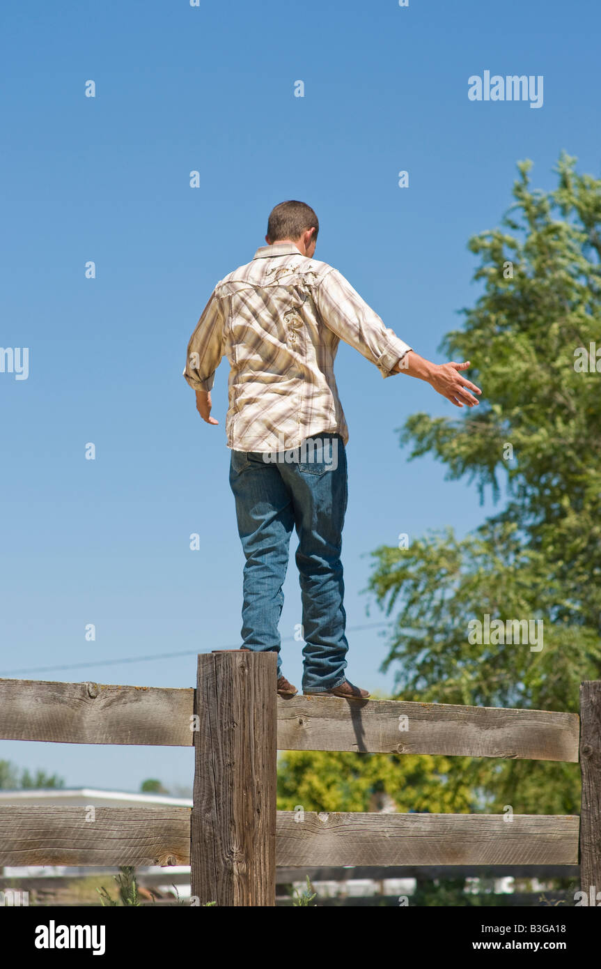 A man walks on a fence on a farm Stock Photo - Alamy