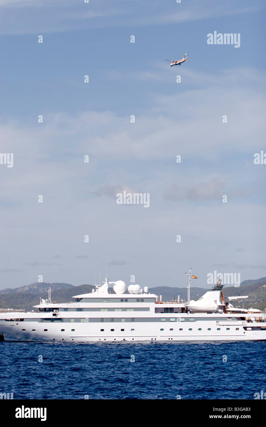Plane fliyng over Ibiza and a big yacht Stock Photo - Alamy