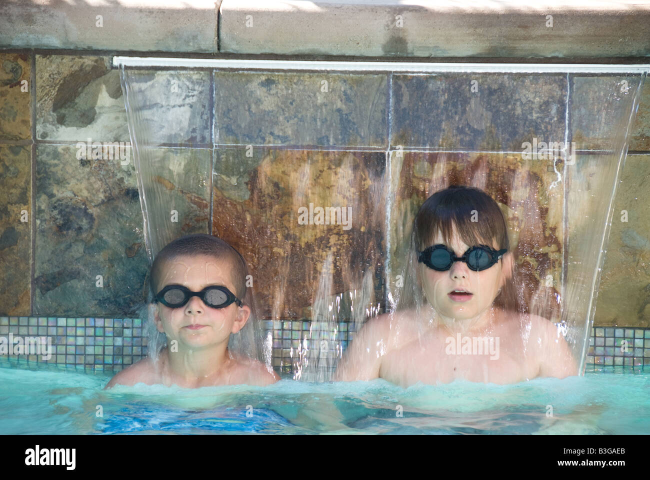 Children enjoys the summer by cooling off in a swimming pool Stock ...