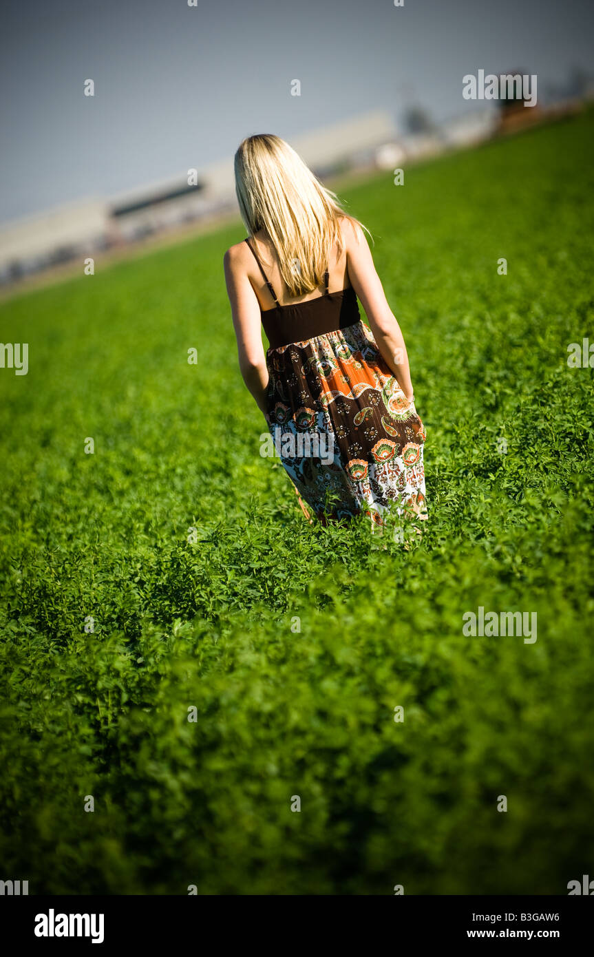 Young girl wades through a green field Stock Photo - Alamy