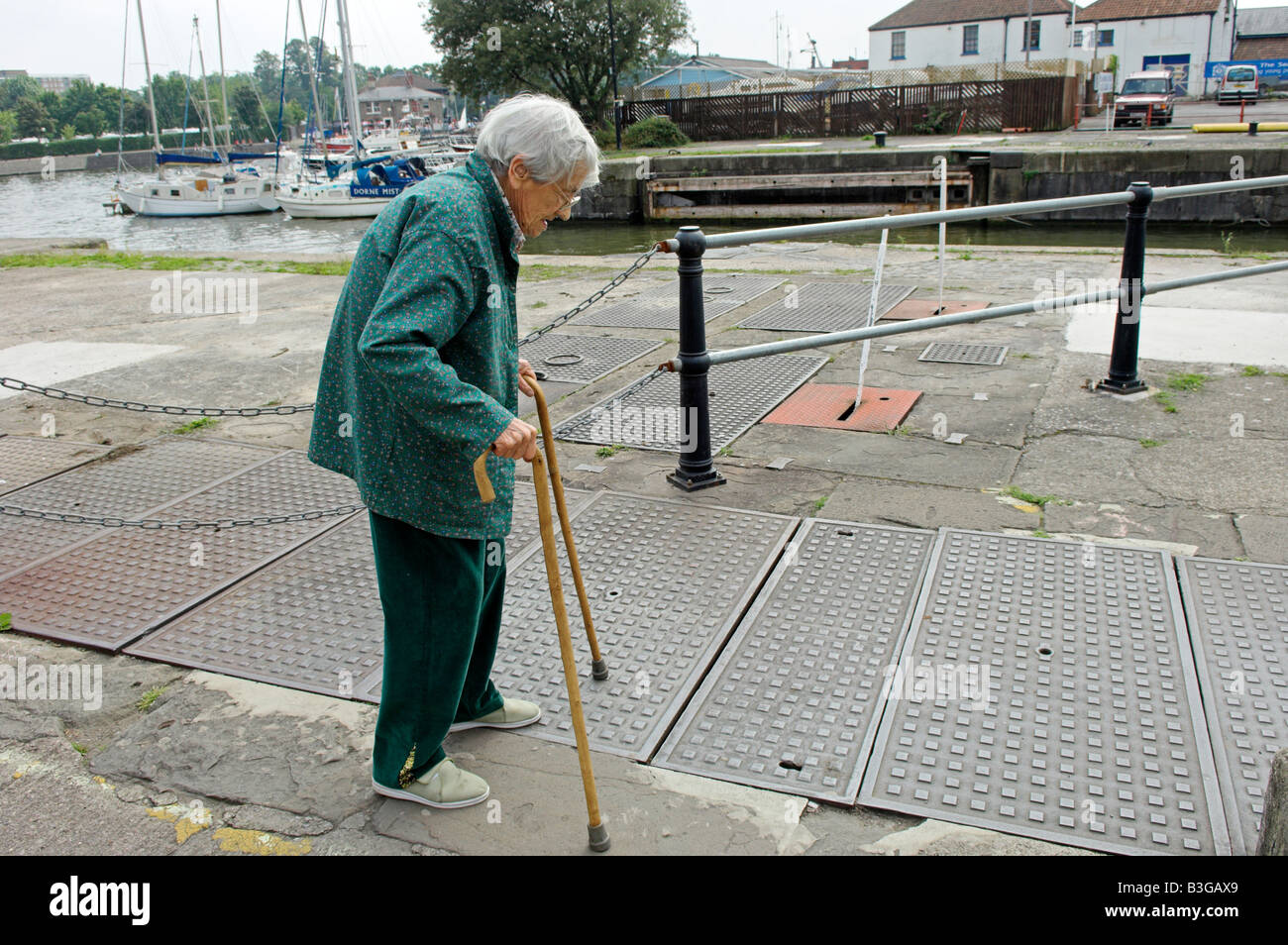 Active elderly English 92 year old woman cautiously walking with two ...