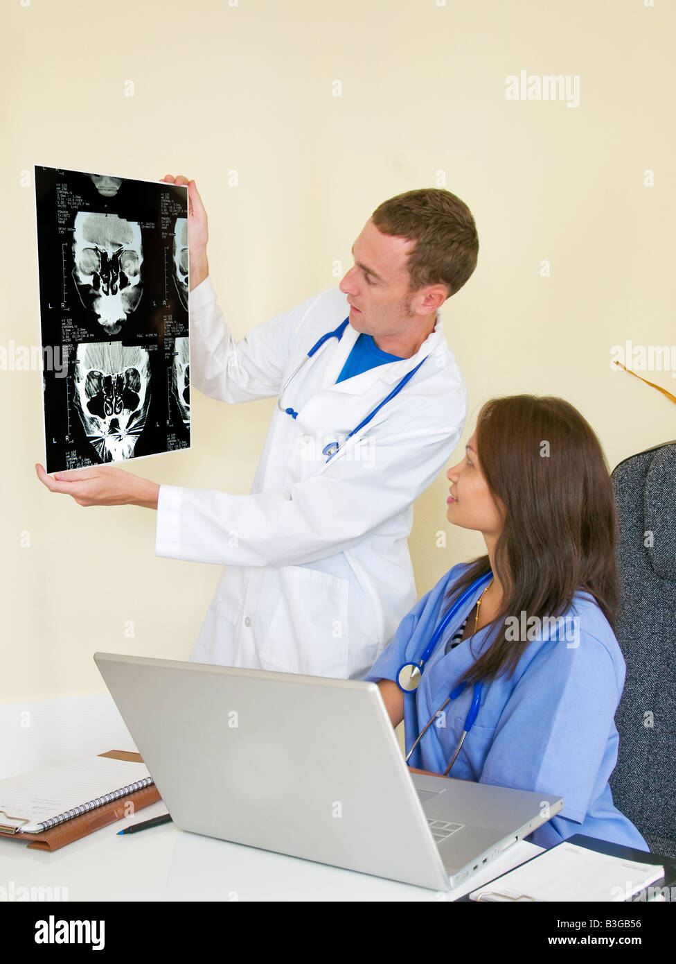Male doctor and Asian female nurse checking x rays Stock Photo - Alamy