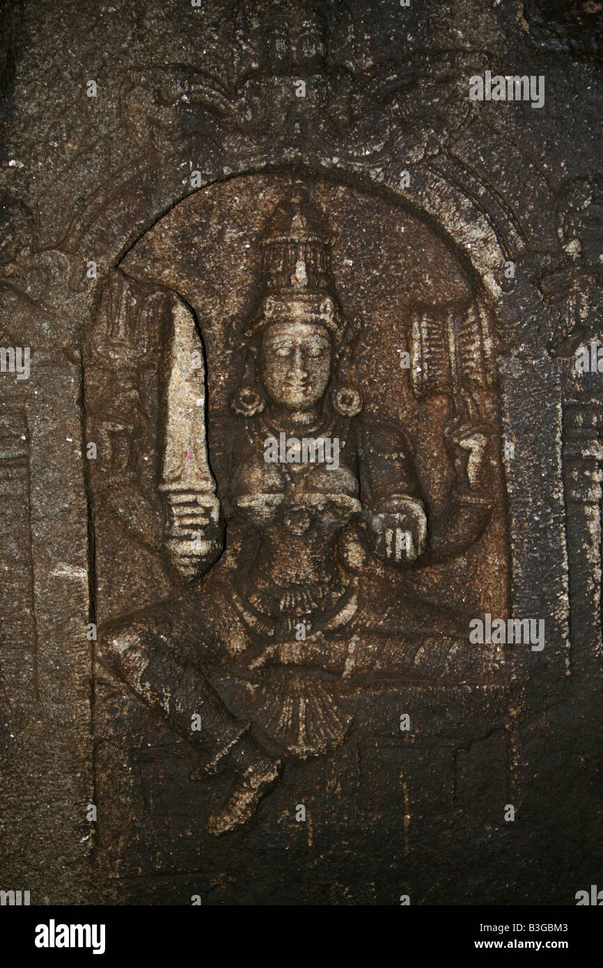 The figure of an ancient Hindu deity in one of the rock temples close ...