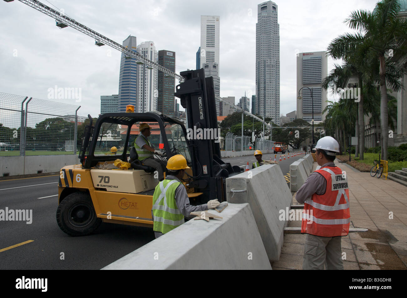 Workers move barriers into place with a forklift as they prepare the ...