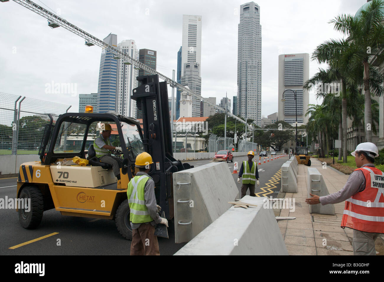 Workers move barriers into place with a forklift as they prepare the ...
