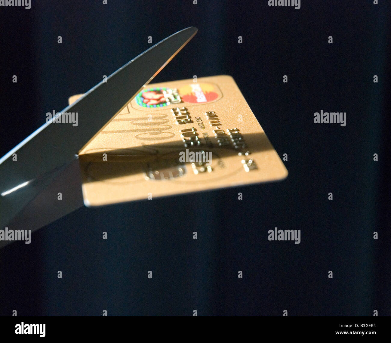 Credit card being cut by scissors Stock Photo - Alamy