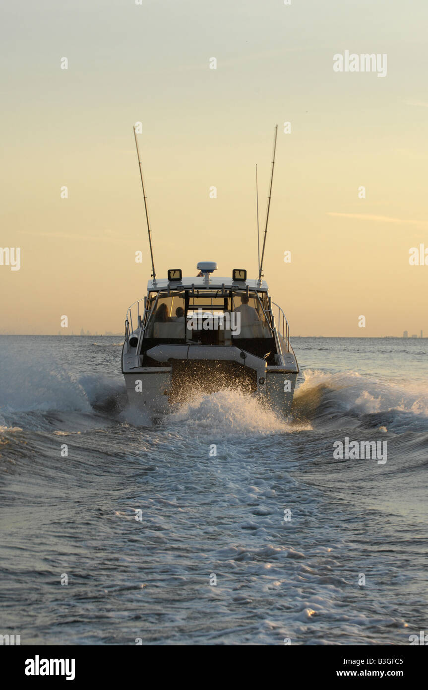 A fishing launch heads out into the Long Island Sound at sunset Stock ...
