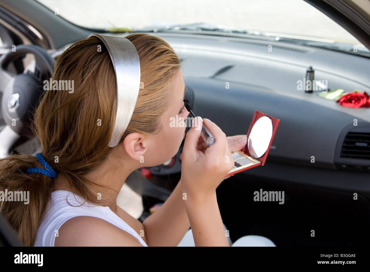 Beautiful girl make make up in the car Stock Photo - Alamy