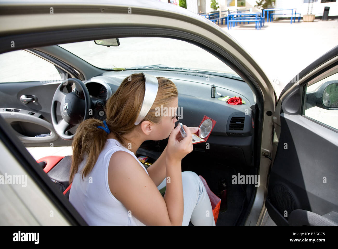 Beautiful girl make make up in the car Stock Photo - Alamy