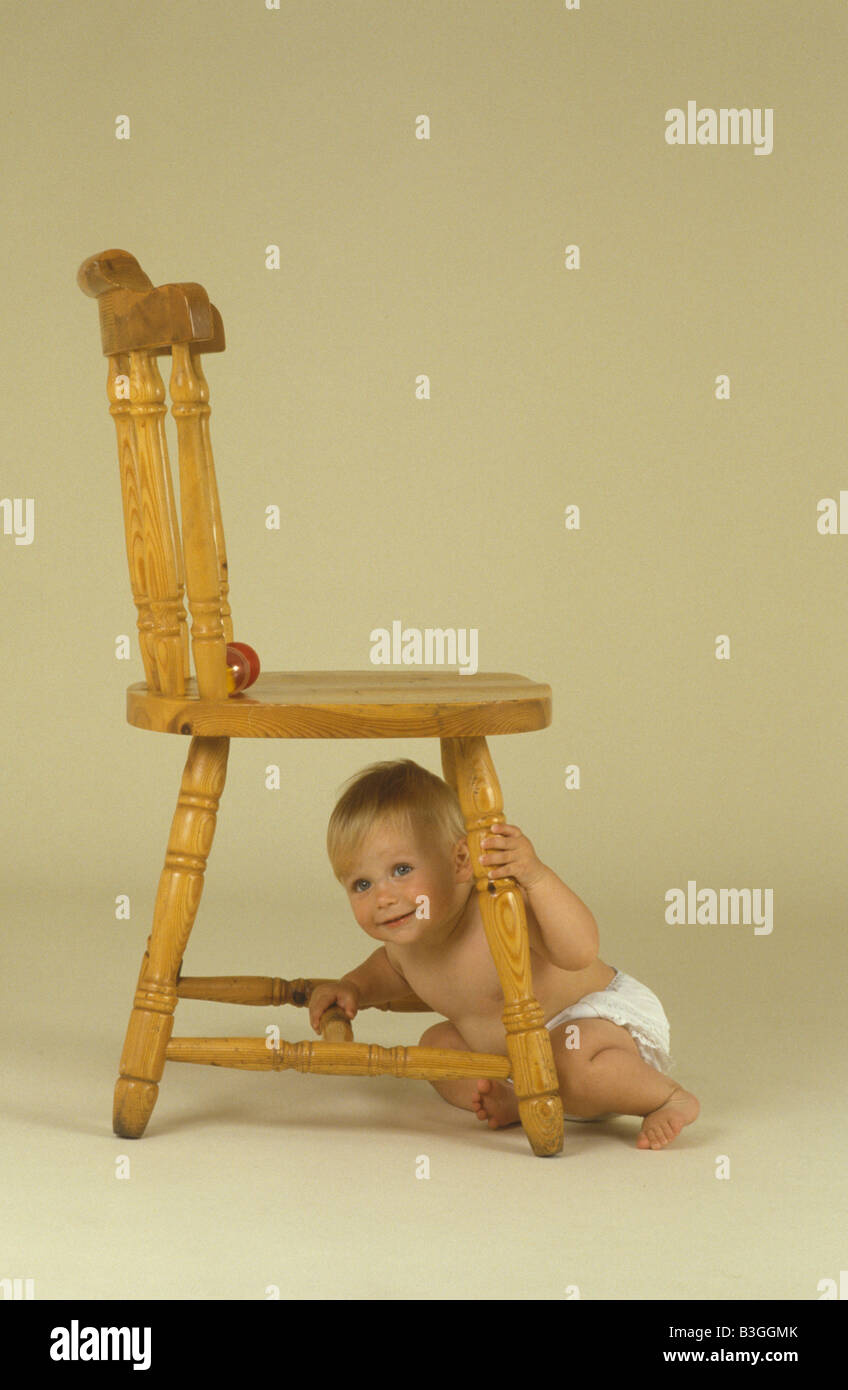 toddler crouching under a chair Stock Photo - Alamy