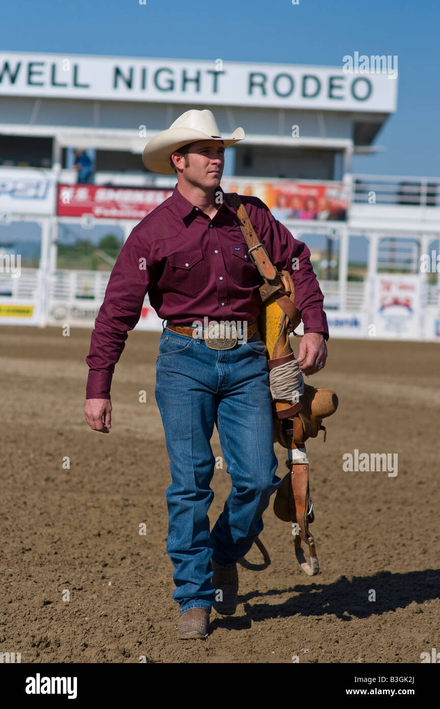 Idaho. A cowboy walks in a rodeo with his saddle Stock Photo - Alamy