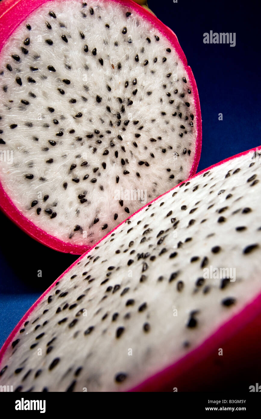 Wide angle close up shot of a sliced open dragon fruit against a dark ...