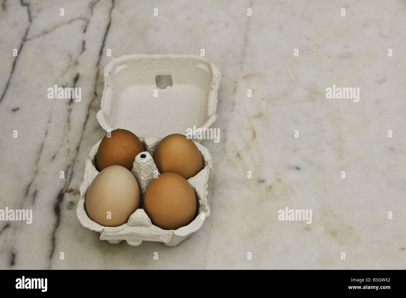 four eggs in their box Stock Photo - Alamy