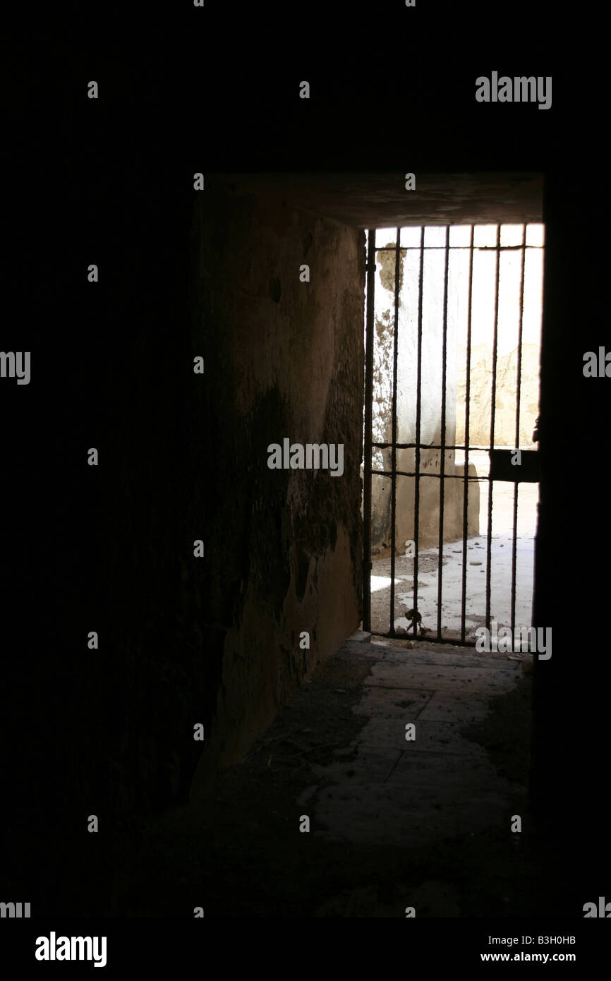 one secluded prison cell door in dark black room Stock Photo - Alamy