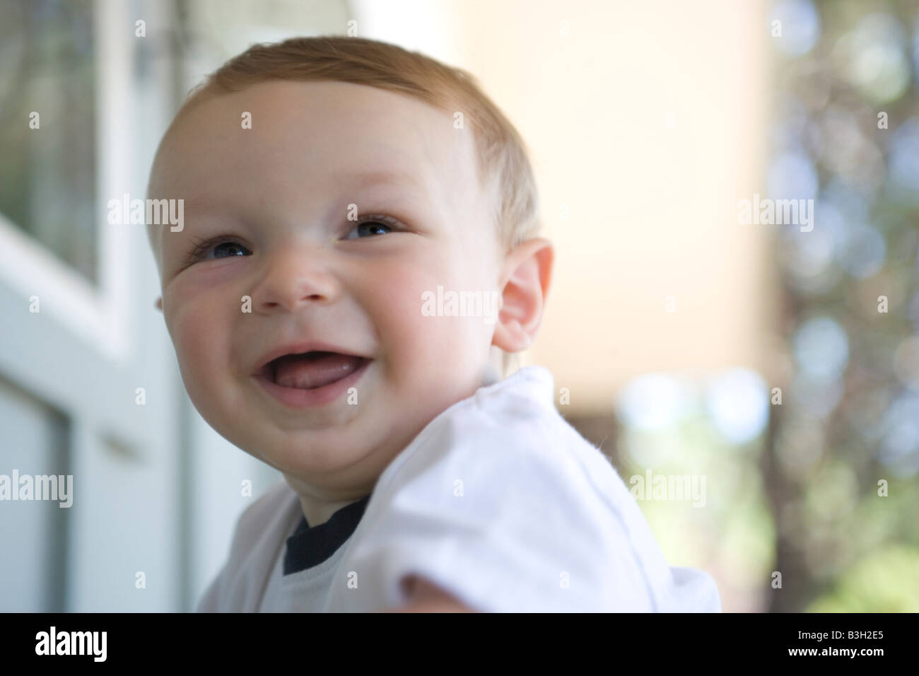 close up of eight month old baby smiling outdoors, confidence, joy ...