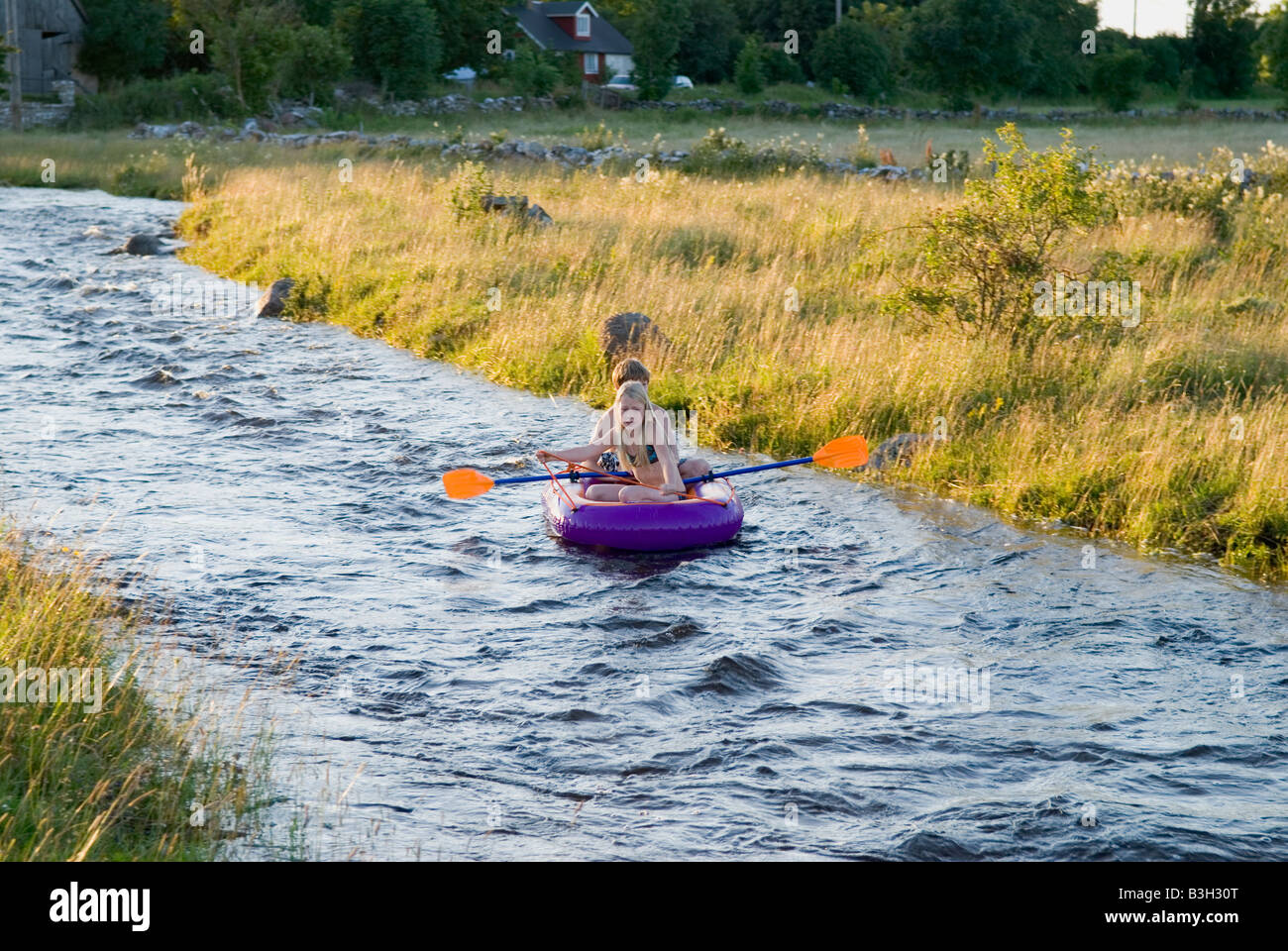 Children in a toy boat in a stream bubbling with the waters of early ...