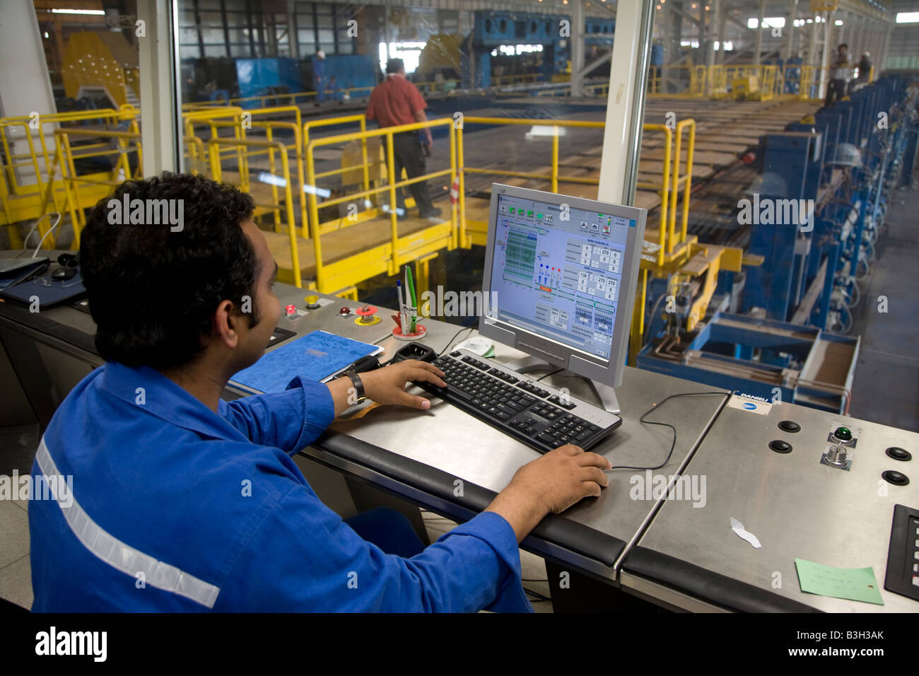 Worker in control booth checking production line at EISF Steel Plant ...