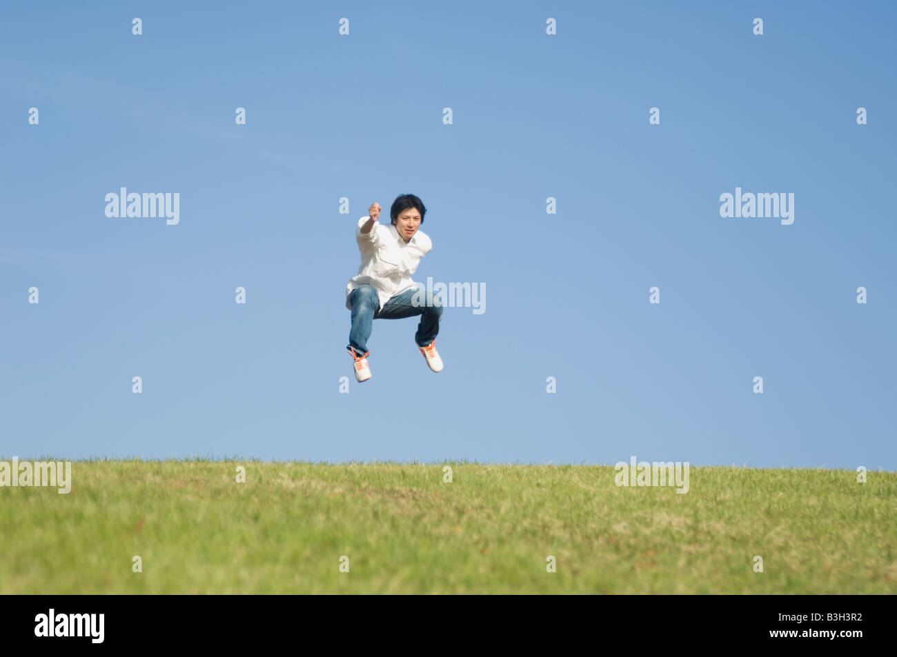 Man jumping on grass Stock Photo - Alamy
