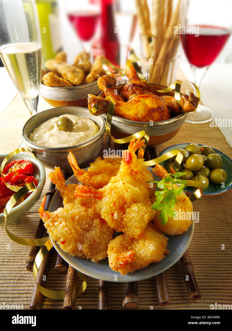 party food buffet with bread sticks, deep fried breaded prawns, green ...