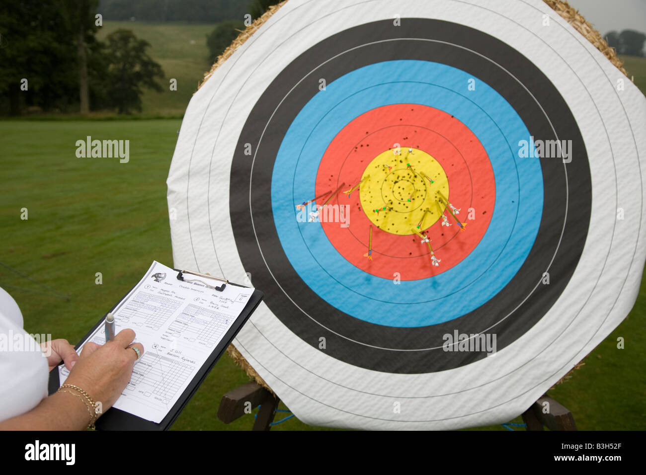 Bullseye Roundel Archery target with arrows woman recording score on ...