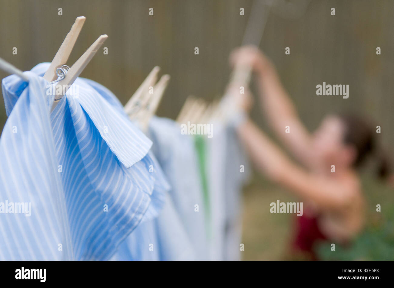 Young woman hanging clothes on a line Stock Photo - Alamy