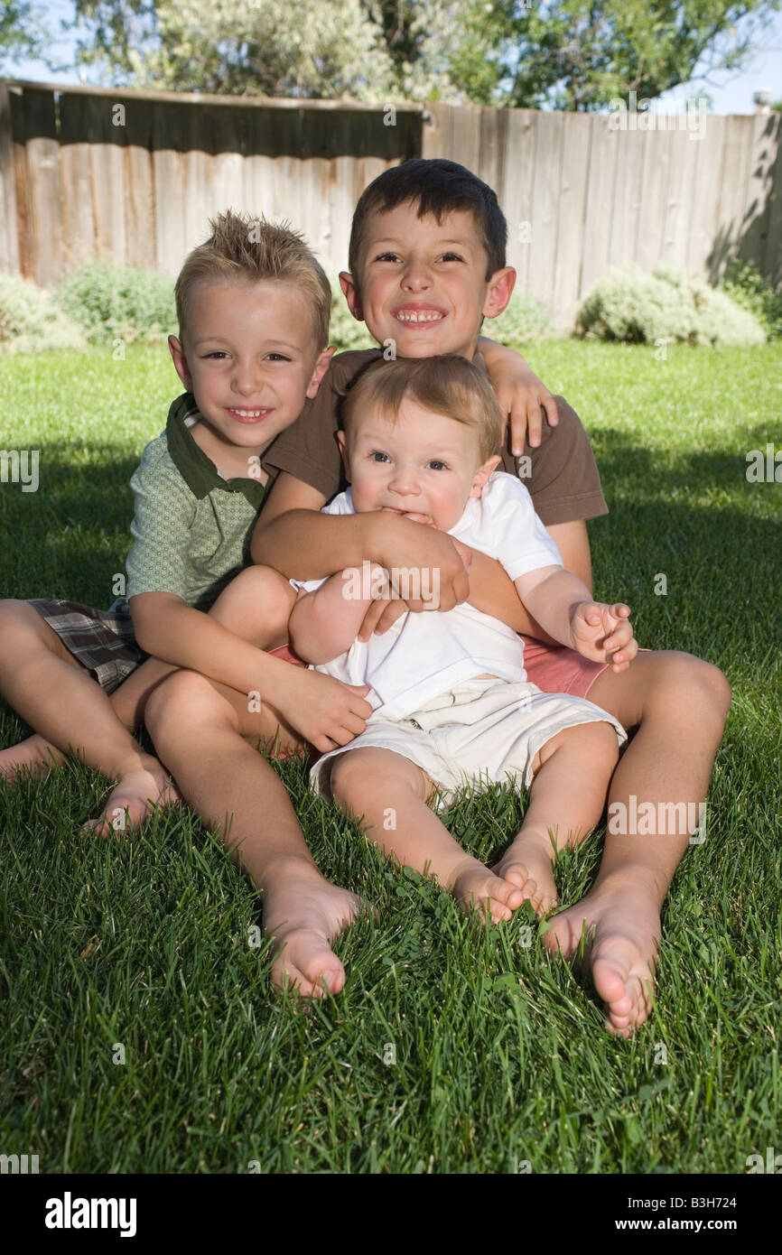 portrait of three brothers outdoors, ages seven, four, and baby Stock ...