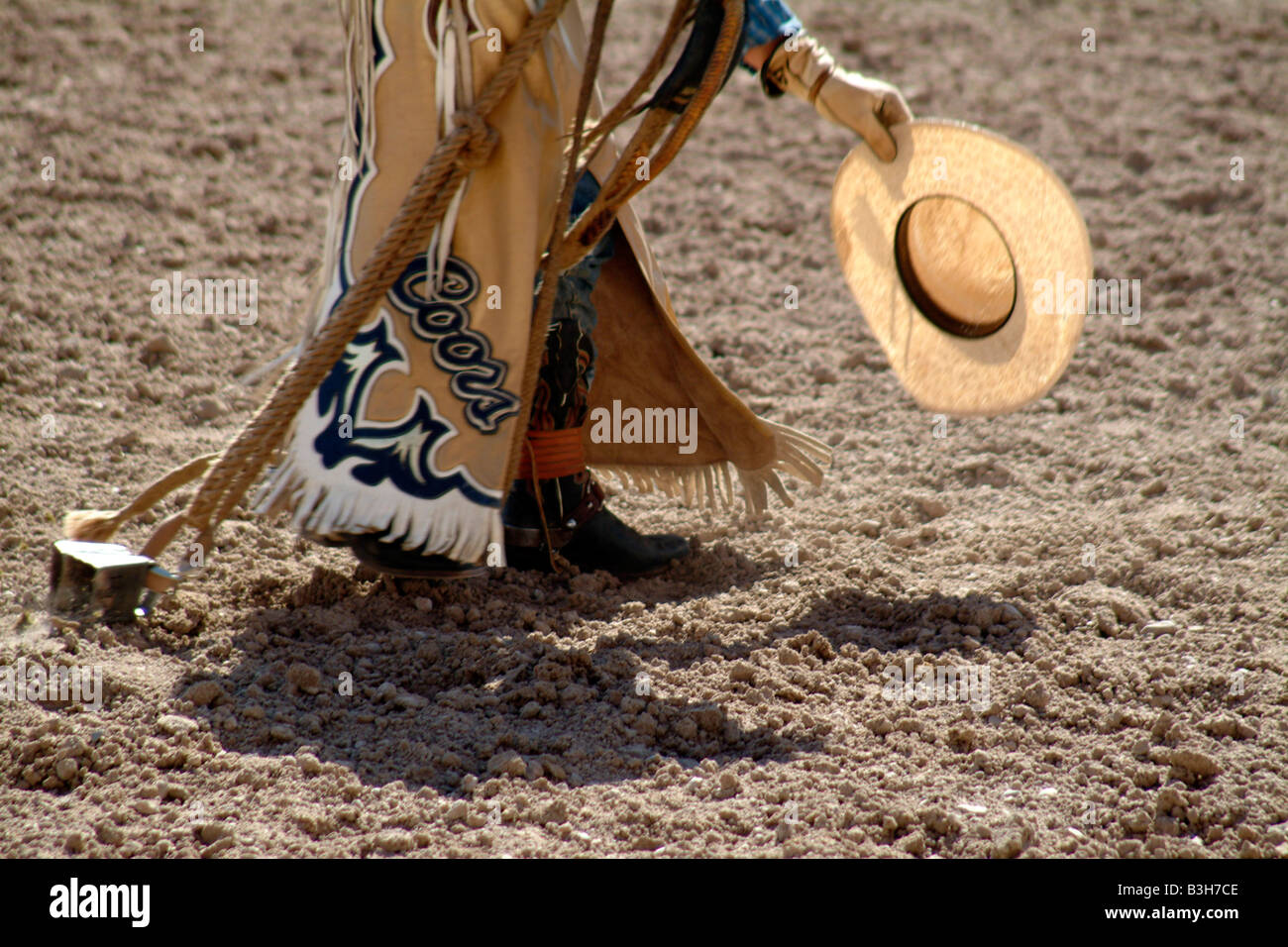 cowboy catching hat at a dust rodeo. old leather boots cheyenne, town ...