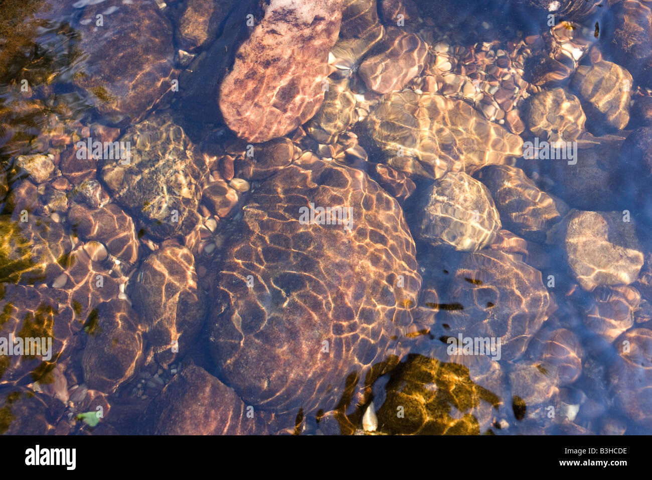 Ripples reflected onto shiny surfaces of rocks and pebbles in the River ...