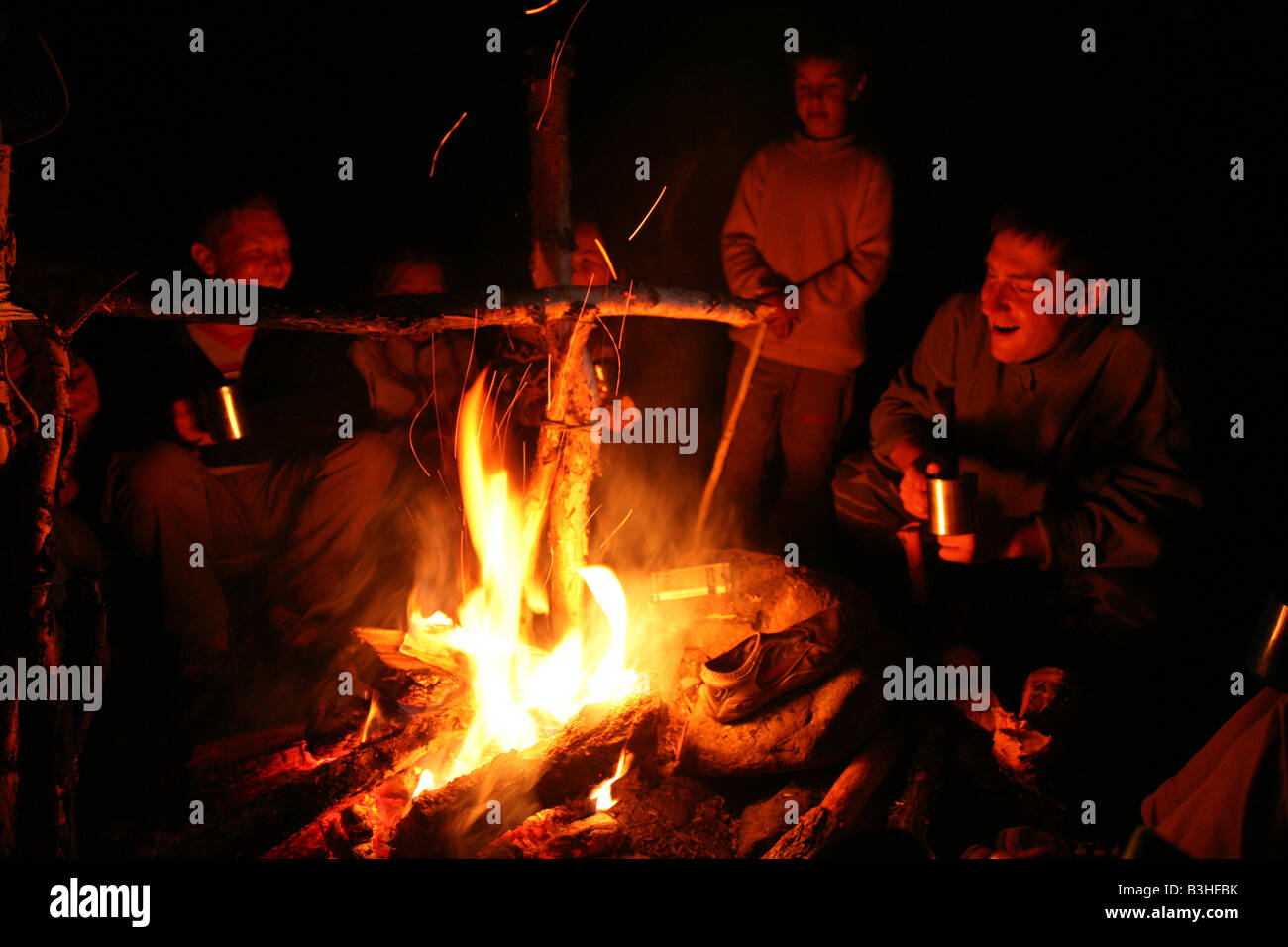 Children sitting around a bonfire at night hi-res stock photography and ...