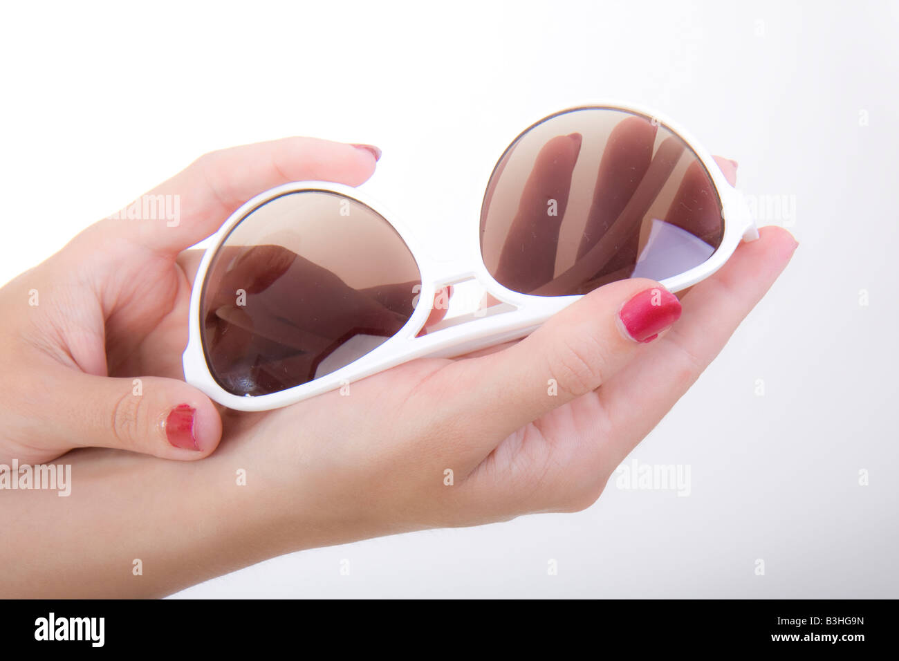 sunglasses held by hands with red painted fingernails Stock Photo - Alamy