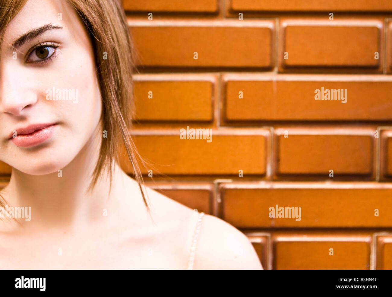 Half face portrait against brick wall background Stock Photo - Alamy