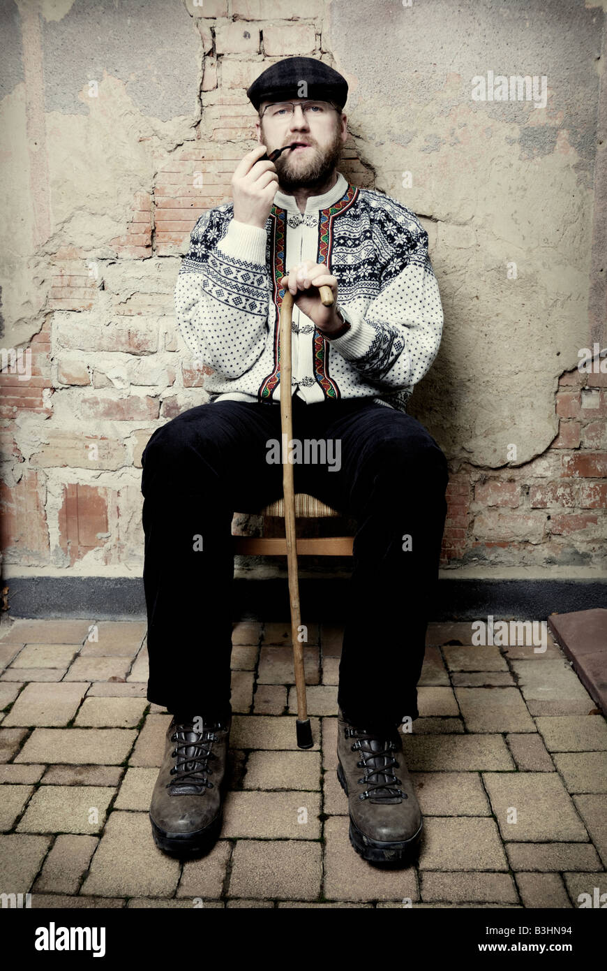 bearded pipe smoker sitting in front of a wall Stock Photo - Alamy