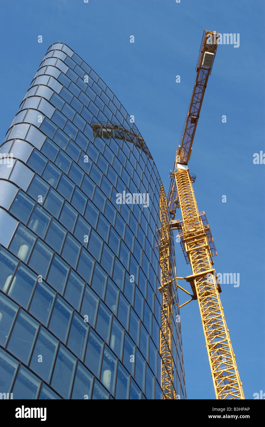 building crane at modern glass facade Stock Photo - Alamy