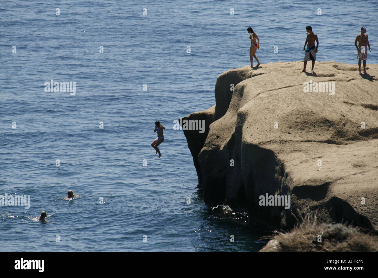 person jumping off rock into sea at venotene island, italy Stock Photo ...