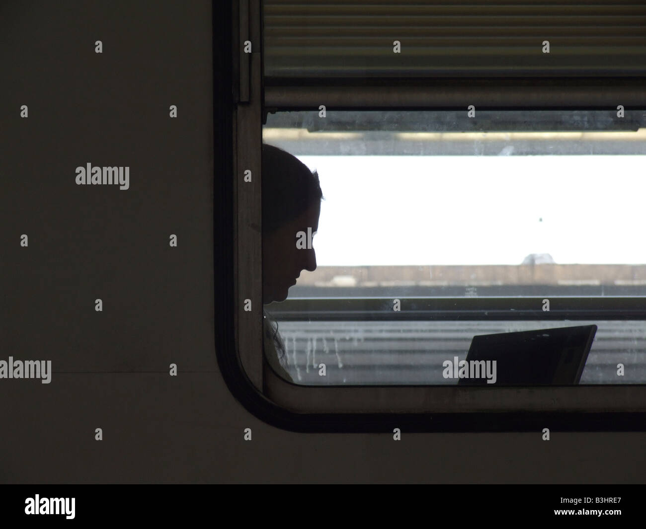 woman working on laptop computer in train station Stock Photo - Alamy