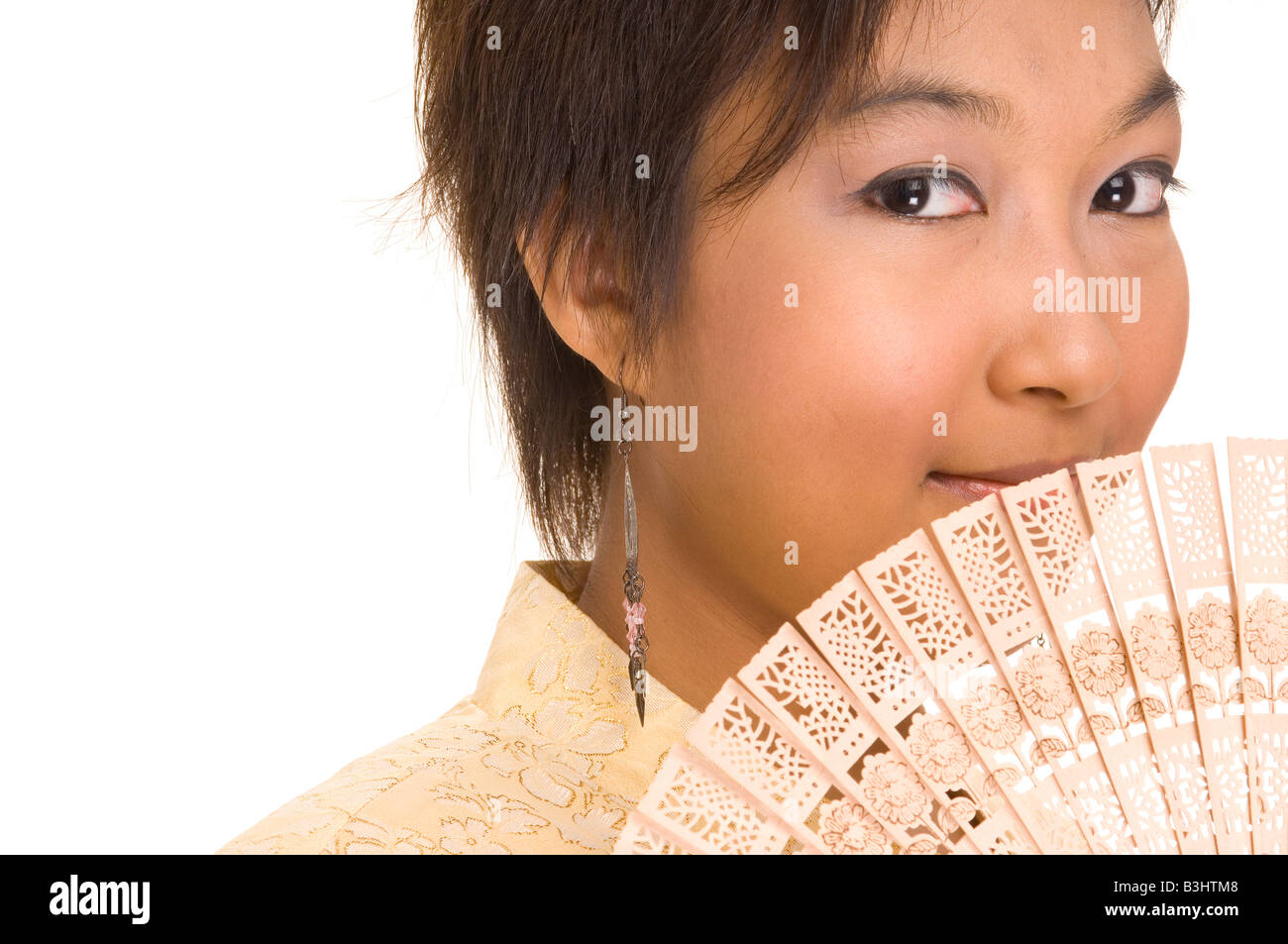 A young asian woman holds a fan to her face Stock Photo - Alamy