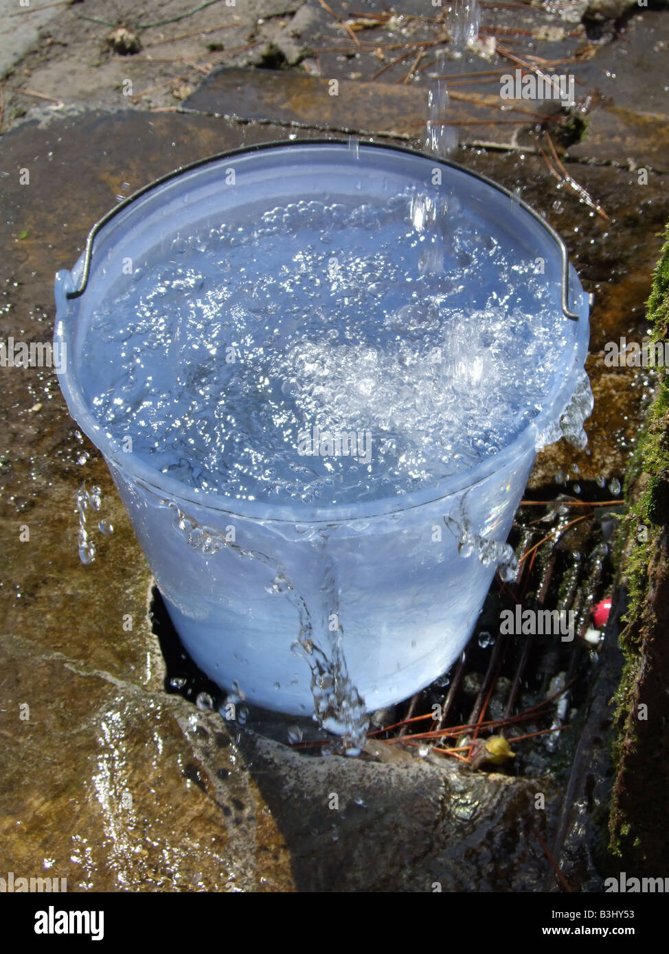 one blue plastic bucket full of water by fountain Stock Photo - Alamy