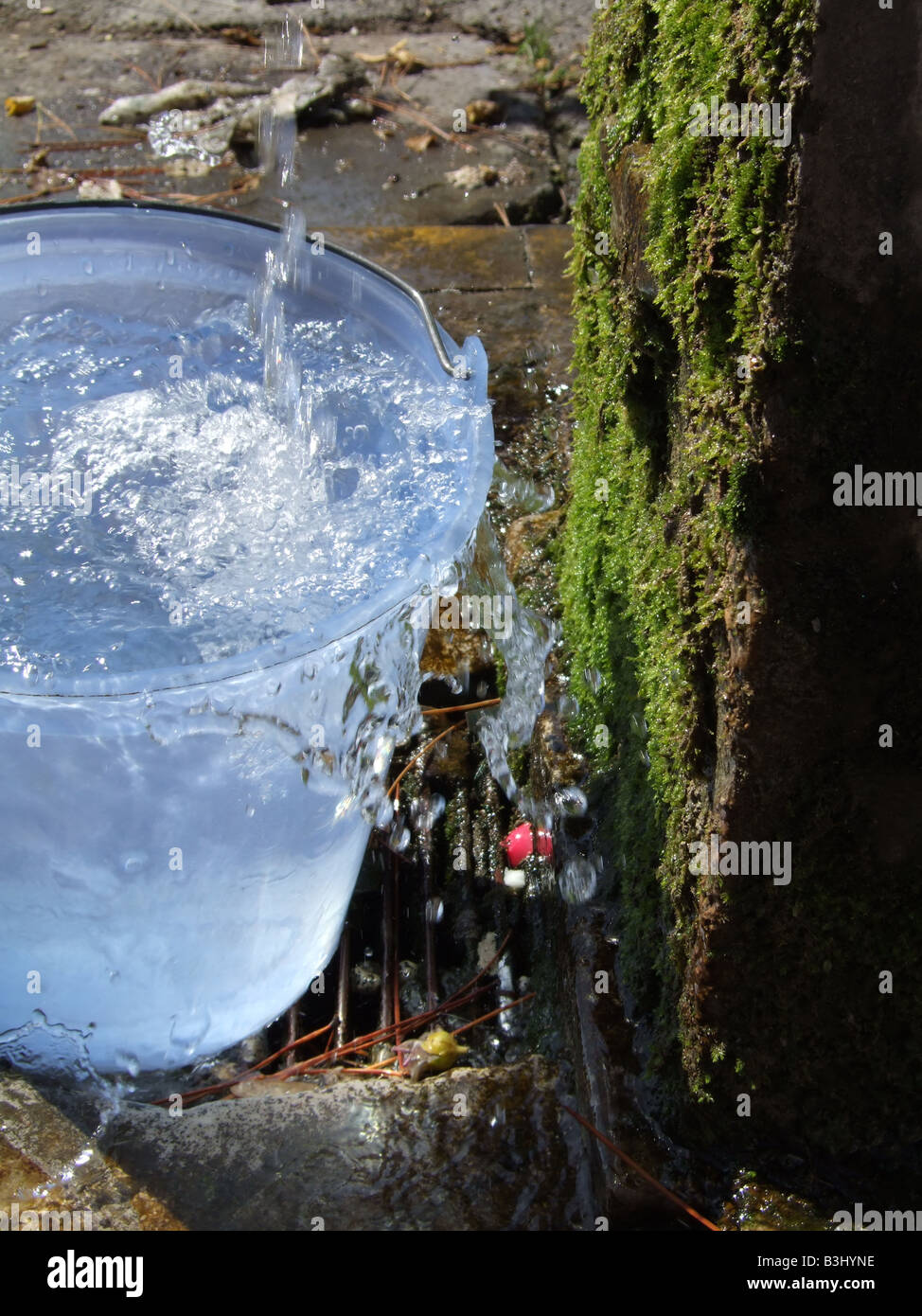 one blue plastic bucket full of water by fountain Stock Photo - Alamy