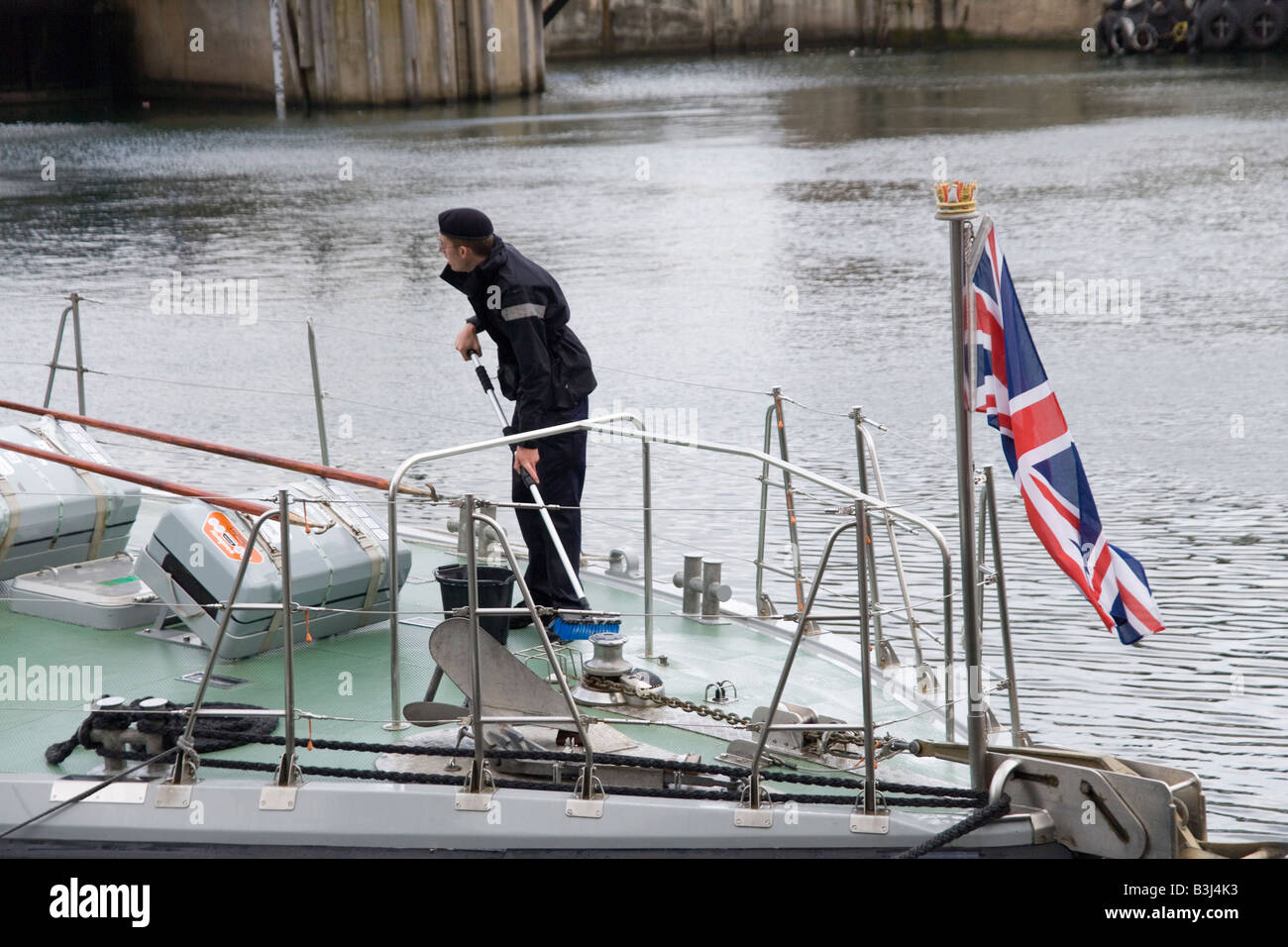 Royal Navy sailor mopping the deck of HMS Ranger at the Tall Ships race ...