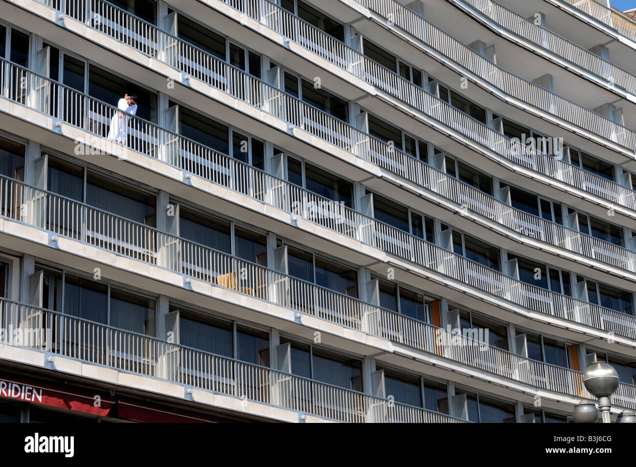 A single person on a balcony of a modern hotel overlooking the ...