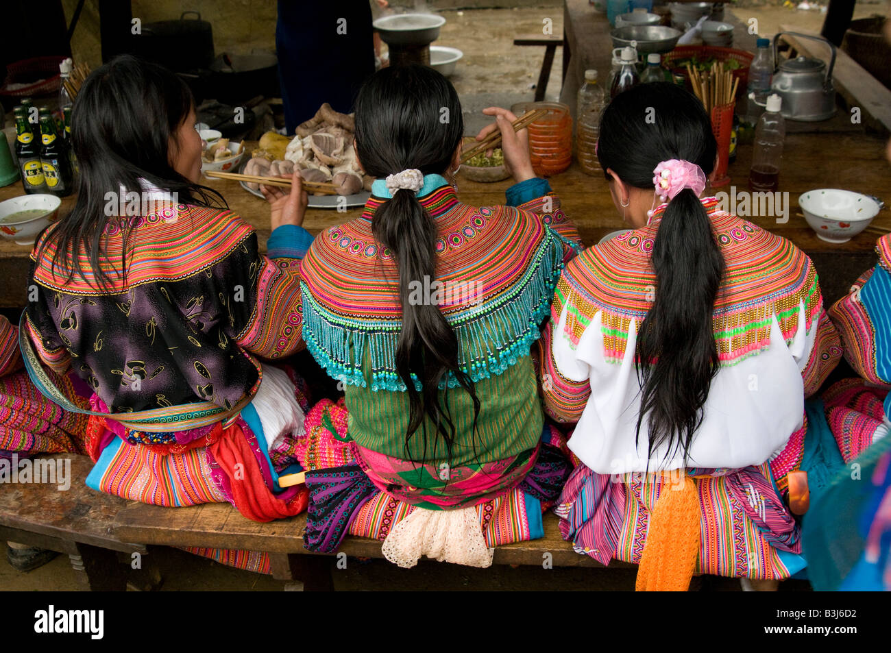 Flower Hmong girls eating lunch at a market stall in Bac Ha market ...