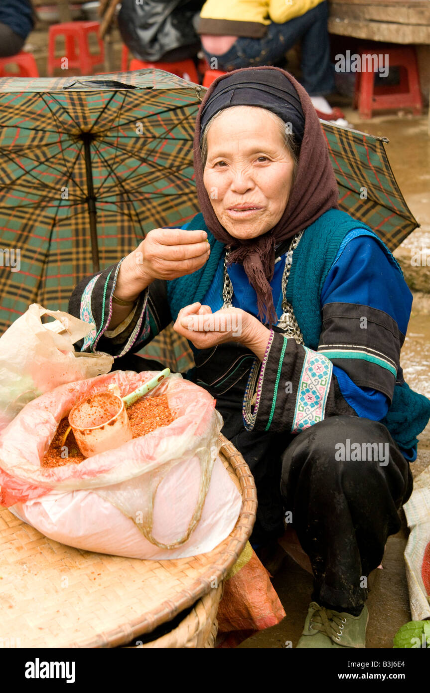 A smiling happy old Hmong woman selling chilli flakes at Bac Ha market ...