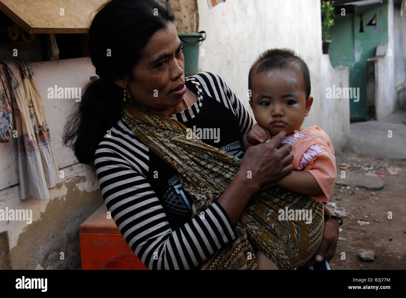 mother with child in slum neighbourhood in kuta , bali , indonesia ...