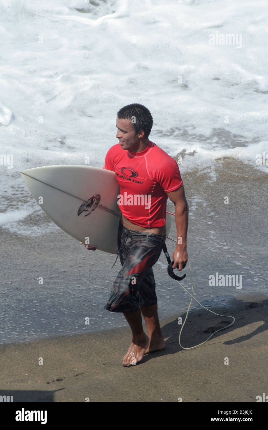 surfer walking along the beach with his surfboard Stock Photo - Alamy